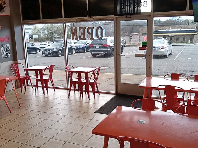 Simple red tables and chairs create an unpretentious dining space where the food, not the decor, rightfully takes center stage.