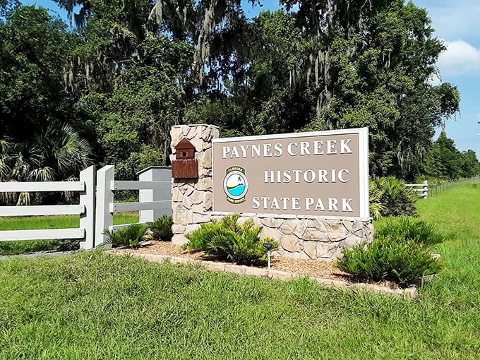 Florida's version of a welcome mat – rustic stone, white fencing, and Spanish moss that practically whispers "y'all come on in now."