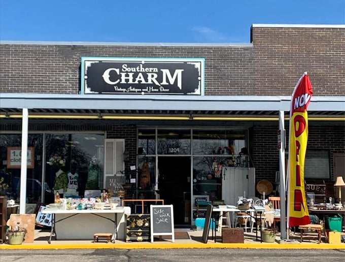 The sidewalk display works like a retail appetizer – just enough vintage garden tools and weathered furniture to make you hungry for the main course inside. 