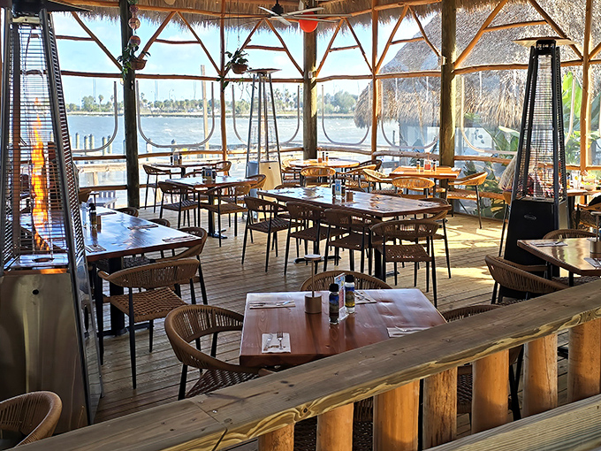 Sunlight streams through the thatched-roof dining area, where every table offers front-row seats to the tranquil Indian River panorama.