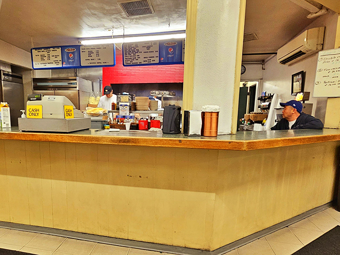 Behind this no-nonsense counter, breakfast dreams come true. The "Cash Only" sign isn't a deterrent—it's a badge of old-school authenticity.