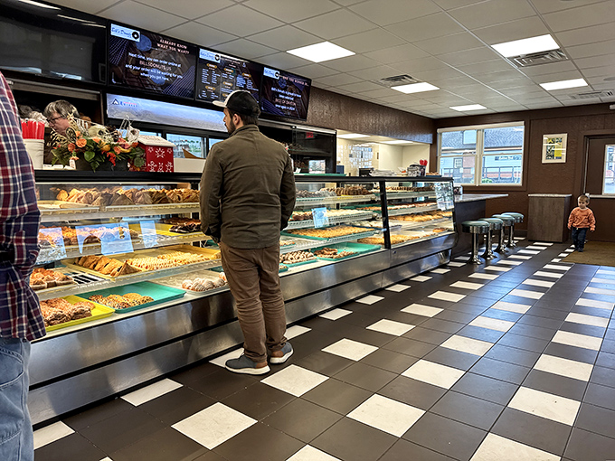 The classic black and white checkered floor leads pilgrims to the promised land – display cases brimming with handcrafted donut perfection.