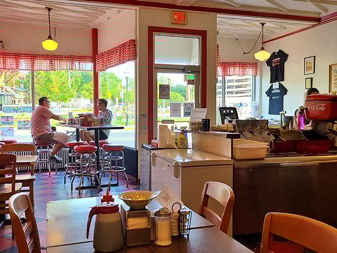 Morning light streams through checkered curtains, illuminating a diner where conversations flow as freely as the coffee. This isn't decoration—it's authentic history.