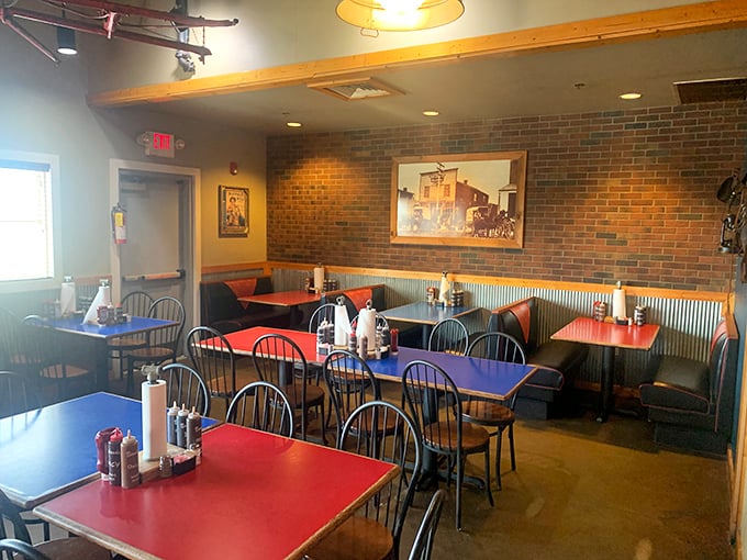 Primary-colored tables pop against exposed brick walls and corrugated metal wainscoting, creating a dining space that's equal parts cowboy comfort and family-friendly charm.