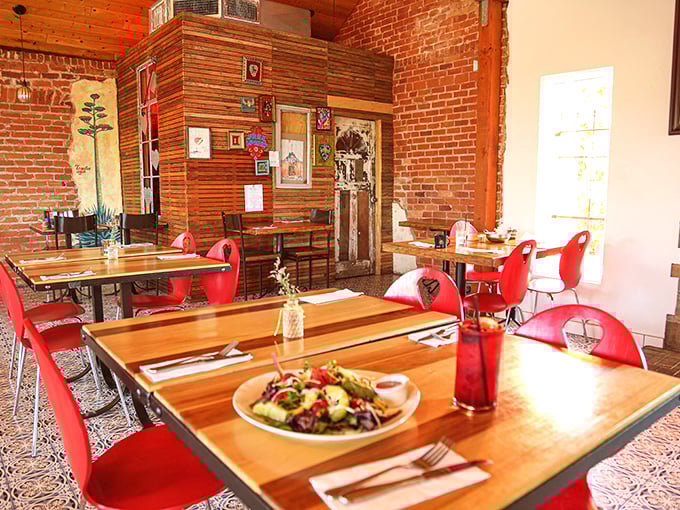 Inside, exposed brick walls meet wooden tables and cherry-red chairs, creating that perfect sweet spot between "neighborhood gem" and "worth driving across town for."