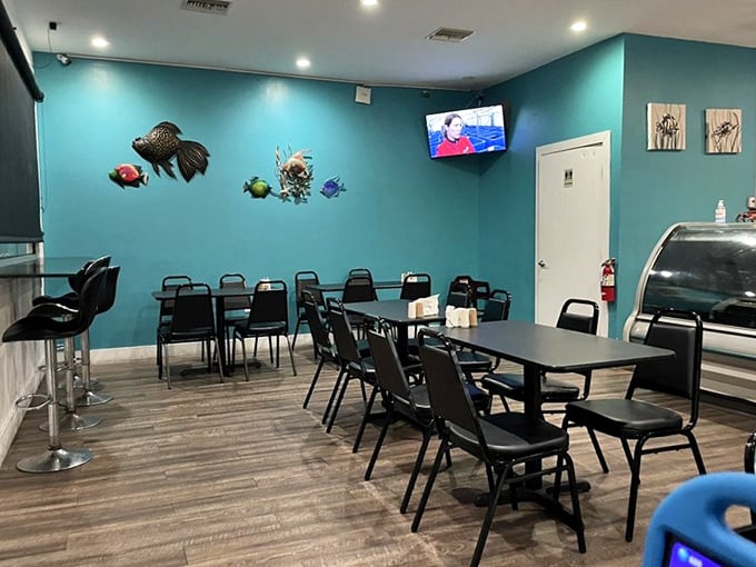 Aqua blue walls adorned with colorful fish sculptures create an underwater vibe that's both charming and unpretentious—like dining in a tasteful mermaid's living room.