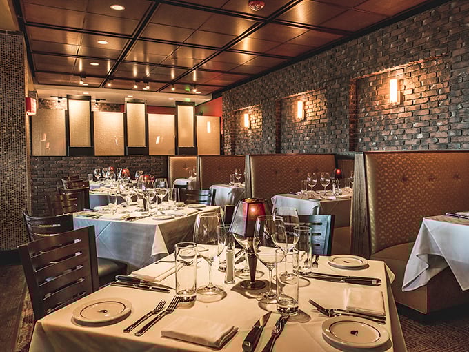Exposed brick walls and leather booths create that classic steakhouse vibe where you half expect Frank Sinatra to walk in and request his usual table.