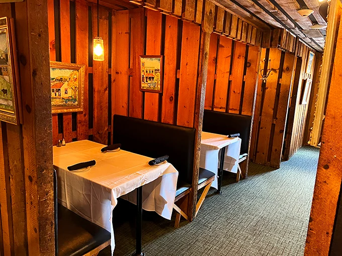 Wooden booths with crisp white tablecloths create intimate dining nooks where conversations flow as freely as the sweet tea.