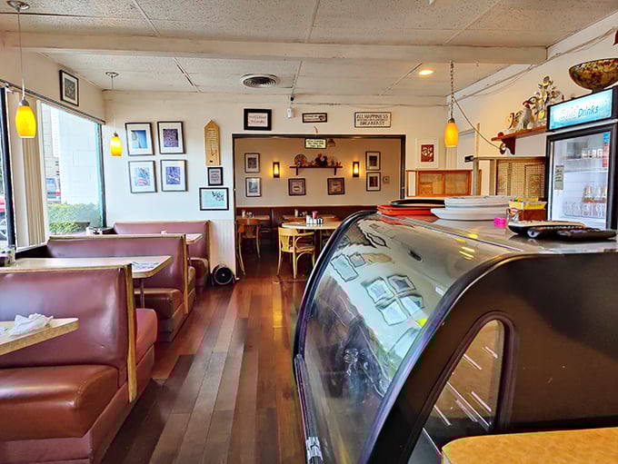Classic red vinyl booths and wood paneling create the perfect time capsule interior where conversations flow as freely as the coffee refills.