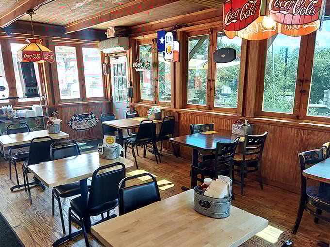 Sunlight streams through windows into this wood-paneled sanctuary of comfort food. The Coca-Cola signs aren't just decoration—they're a promise.