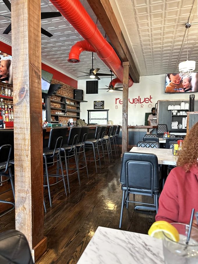 Inside, exposed brick walls meet striking red ductwork, creating a space that's both industrial-chic and warmly inviting.