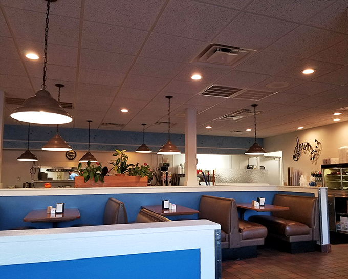 Classic diner aesthetics done right—blue accents, pendant lighting, and comfortable booths where food-induced happiness regularly occurs.