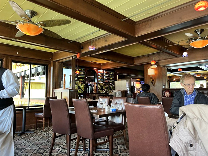 Rich wood beams, leather chairs, and those ceiling fans spinning lazily overhead—this isn't just dining, it's a maritime time capsule with table service.