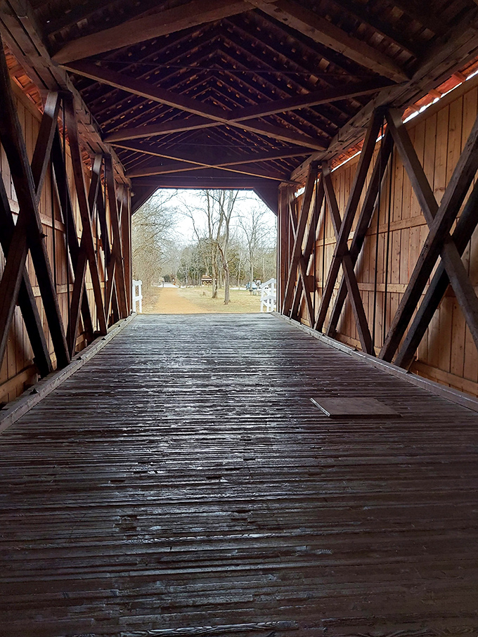 Inside the bridge, a masterclass in 19th-century engineering reveals itself—crisscrossing wooden trusses creating a geometric dance of shadows and light.
