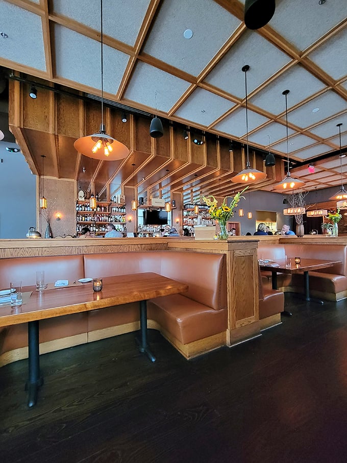 Warm wood tones, leather booths, and that geometric ceiling—this isn't your grandfather's steakhouse, but he'd approve nonetheless.