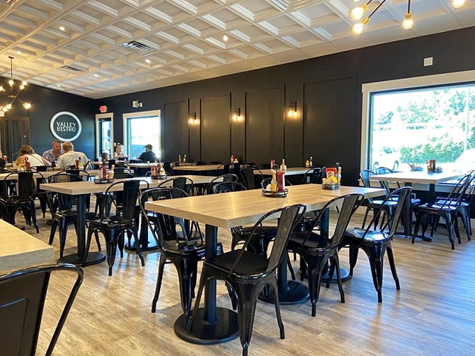 The modern interior balances industrial chic with comfort—black metal chairs and that stunning coffered ceiling create drama without pretension.