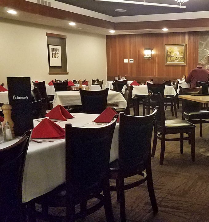 White tablecloths, wood paneling, and those perfectly folded red napkins—the dining room practically whispers "take your time, we've got all evening."