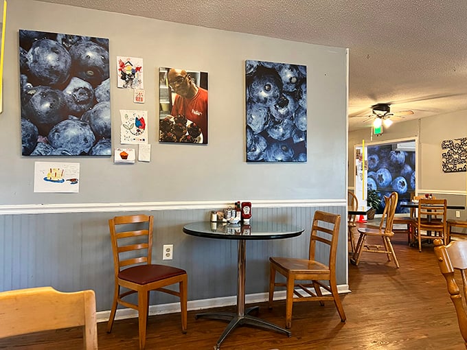Blue walls adorned with blueberry portraits create an atmosphere that's both whimsical and comforting, like breakfast at your artistic aunt's house.