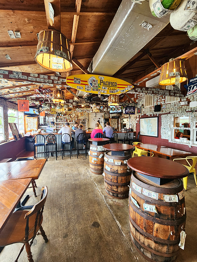 Dollar bills wallpaper the ceiling while barrel tables invite you to settle in—this isn't just decor, it's decades of delicious memories.