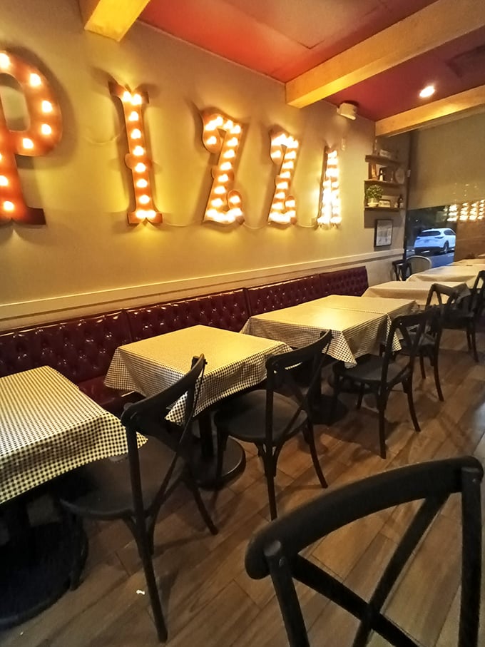 The illuminated "PIZZA" sign isn't just decoration—it's more like a marquee announcing the main attraction in this cozy Italian theater of deliciousness.
