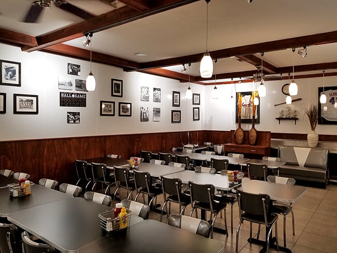 Classic diner ambiance meets Florida charm. Black and white photos line wood-paneled walls while pendant lights cast a warm glow over tables ready for breakfast magic.