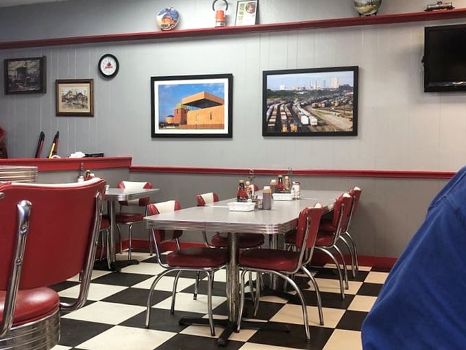 Classic diner aesthetics done right—red vinyl chairs, chrome accents, and that iconic black-and-white checkered floor. Nostalgia you can sit on.