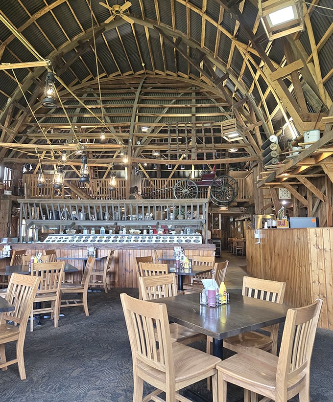 Soaring wooden beams create a cathedral-like space where farm implements become art and conversations echo with laughter and satisfaction.