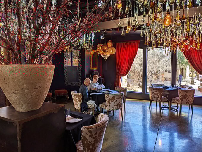 Dining under a constellation of colorful glass teardrops while red curtains frame the desert beyond—this isn't your average Taco Tuesday spot.