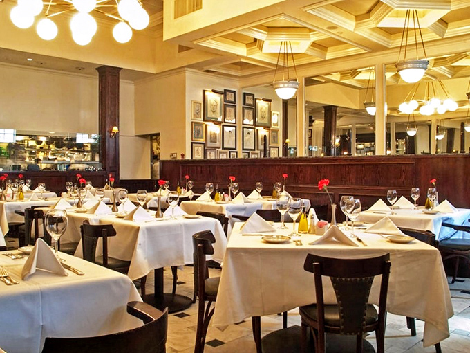 White tablecloths, rich wood paneling, and that magnificent coffered ceiling—this isn't just a restaurant, it's a time machine to when dining was an event.