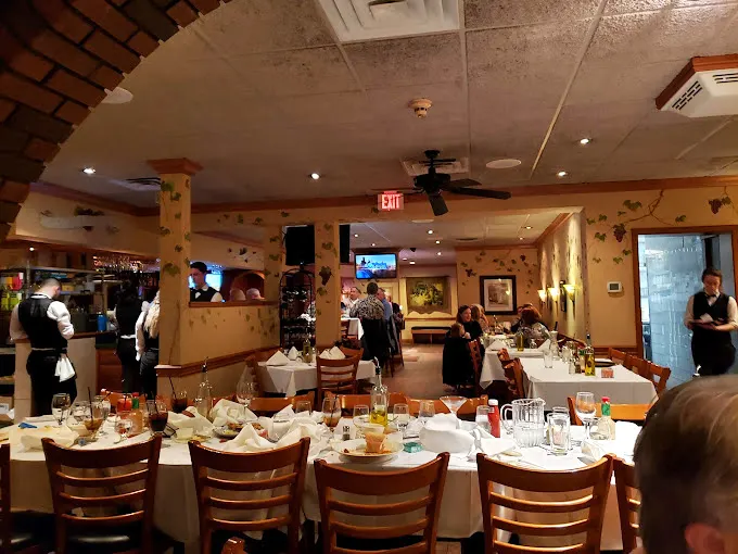The dining room buzzes with that magical Italian restaurant energy—white tablecloths, warm lighting, and the promise of imminent carbohydrate bliss.