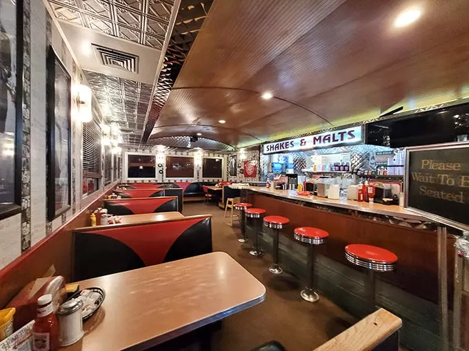 Step inside and you're transported to simpler times—red vinyl booths, counter seating, and that "Shakes & Malts" sign promising creamy delights ahead.