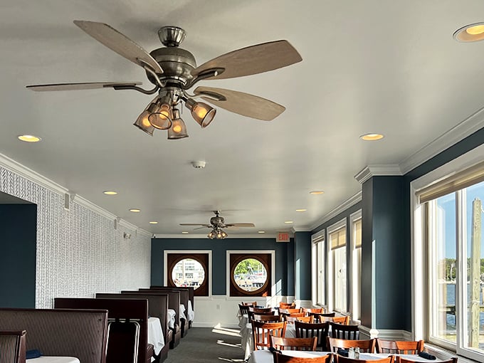 Inside, nautical charm meets comfortable dining where ceiling fans keep things cool and conversations flow freely.