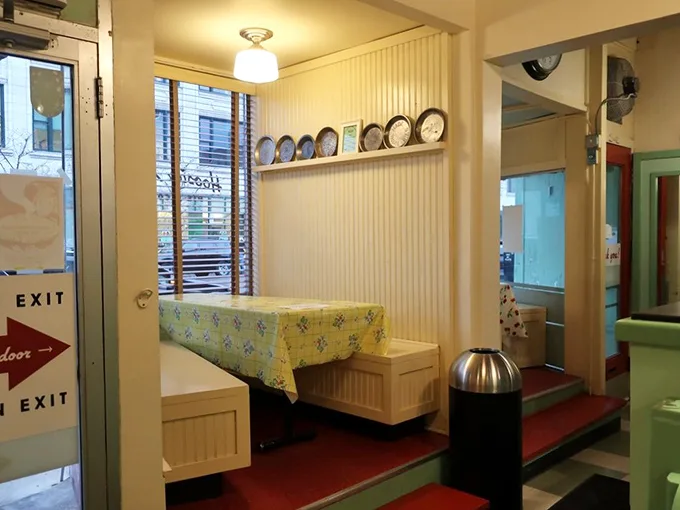 Step inside this cozy haven where vintage charm meets modern comfort, complete with decorative plates watching over diners.