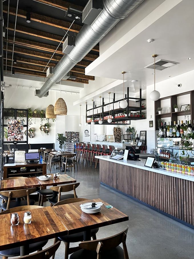 Inside, industrial chic meets Italian warmth with exposed beams, woven pendant lights, and wooden tables that practically beg you to settle in for "just one more slice."