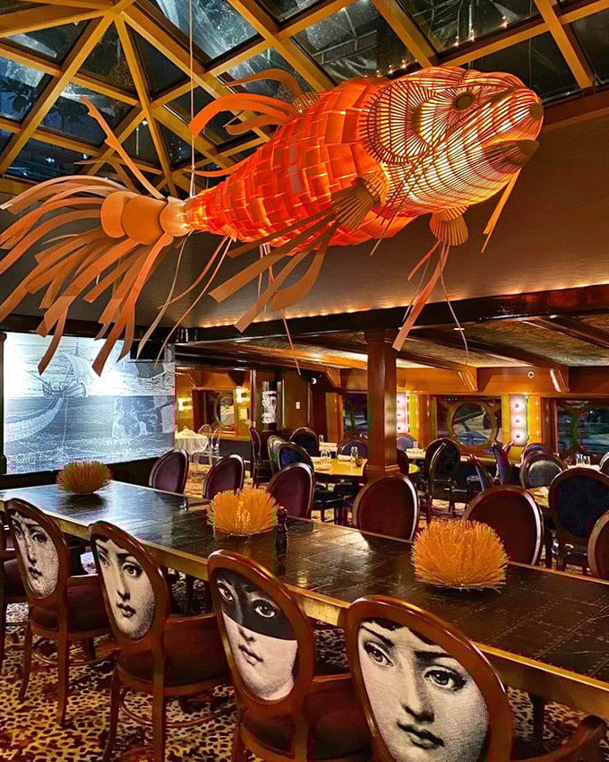 Dining under an illuminated orange fish installation while surrounded by artistic chairs isn't just dinner—it's theater. The Moshulu's interior design philosophy clearly states: "ordinary belongs elsewhere."