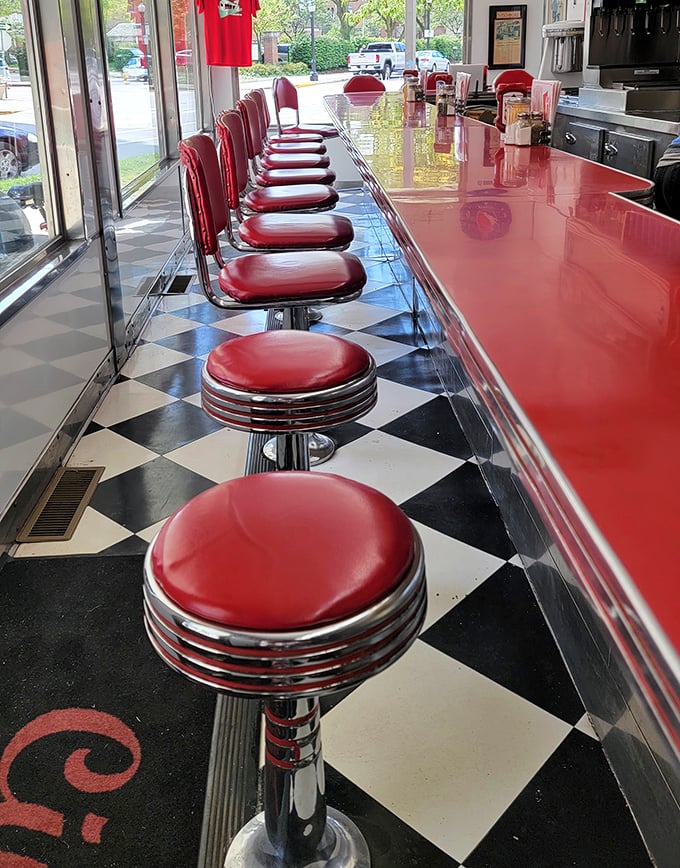 Fifteen red stools lined up like soldiers at the gleaming counter—each one a front-row seat to breakfast theater where regulars become neighbors.