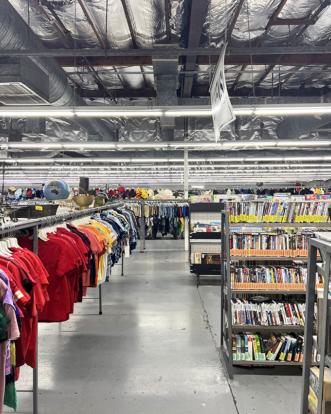Industrial ceilings and color-coded racks create a surprisingly organized chaos—like a library where fashion history is catalogued by hue instead of Dewey Decimal.