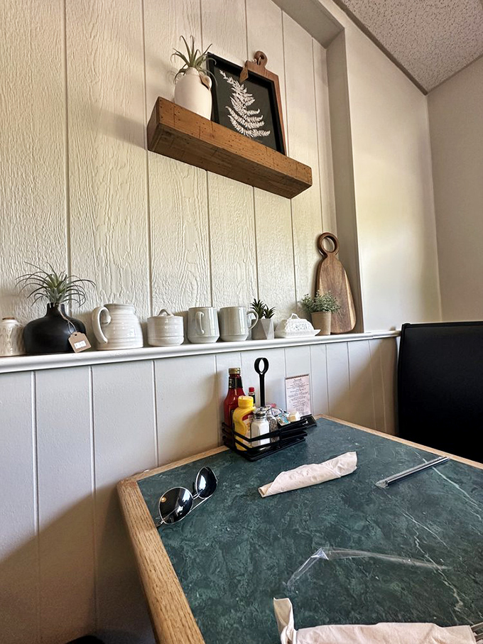 Rustic wooden shelves adorned with ceramic mugs and simple greenery create that "grandma's house" feeling—where calories don't count and seconds are mandatory.
