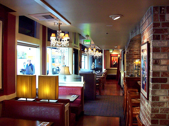 Elegant chandeliers hang above cozy brick walls and warm wood tones. This isn't just a restaurant—it's Pasadena's living room where breakfast dreams come true.