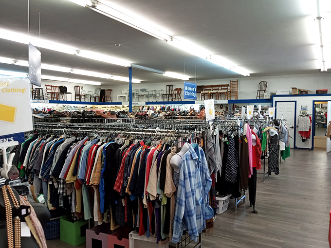 Rows of clothing stretch like a fabric rainbow, each piece waiting for its second act.
