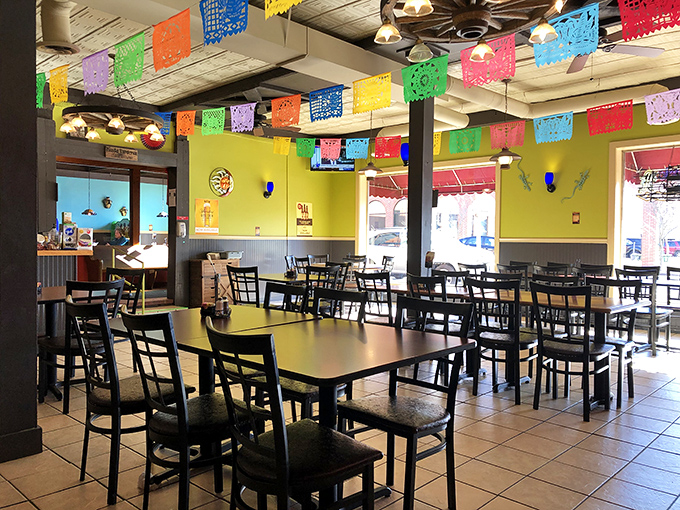 Papel picado flags dance overhead like colorful guardians of good times. The bright yellow walls aren't just cheerful—they're setting the stage for flavor fireworks to come.