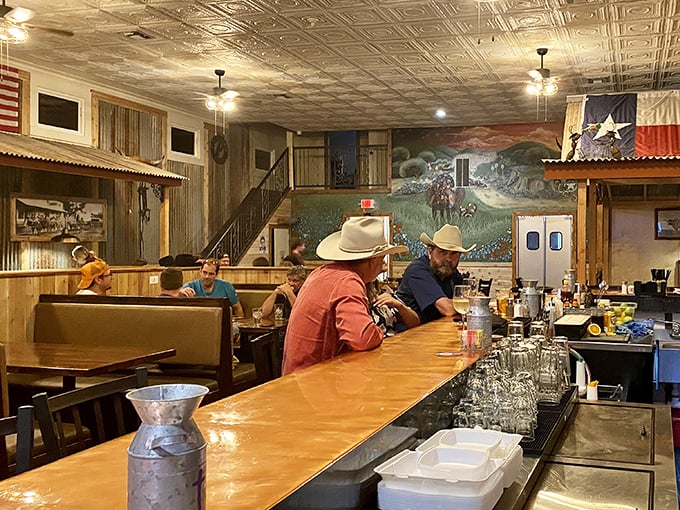 Where Texas pride meets comfort – cowboy hats aren't just decoration here, they're standard dinner attire. The mural backdrop tells stories while you create your own.