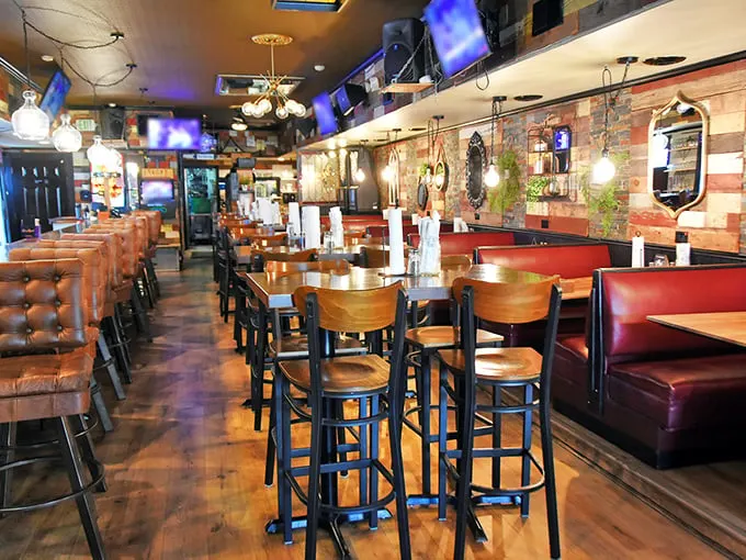 Inside, rustic meets comfort with those red vinyl booths and warm wood tones. The kind of place where calories don't count and conversations flow as easily as the beer.