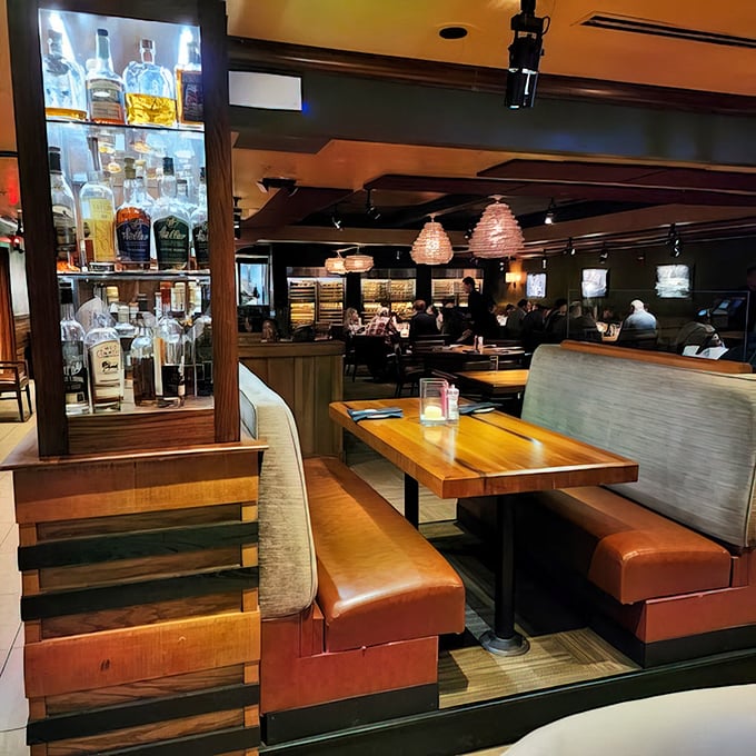 Leather booths and warm wood tones create the perfect backdrop for serious dining decisions. The whiskey display suggests you're in for more than just dinner.