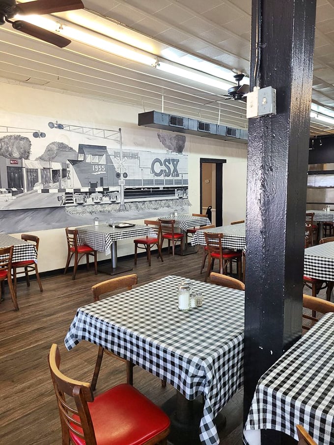 Classic black and white checkered tablecloths set against a railroad mural—dining here is like stepping into a Norman Rockwell painting of the South.