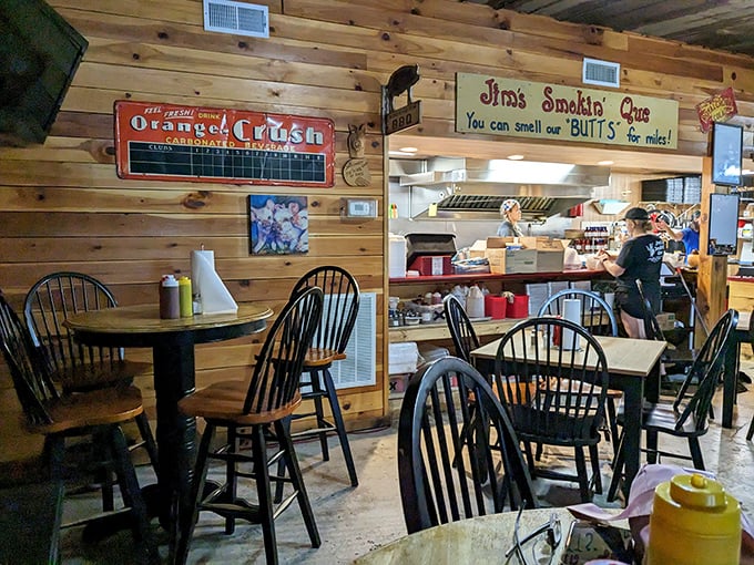 Wooden walls tell stories while that cheeky sign promises what your nose already knows. The open kitchen layout means transparency isn't just a buzzword—it's dinner and a show.