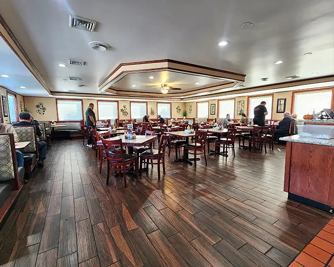 Warm wood floors, red chairs, and that distinctive tray ceiling create the perfect backdrop for breakfast magic. This isn't just dining—it's time travel to when restaurants had soul.
