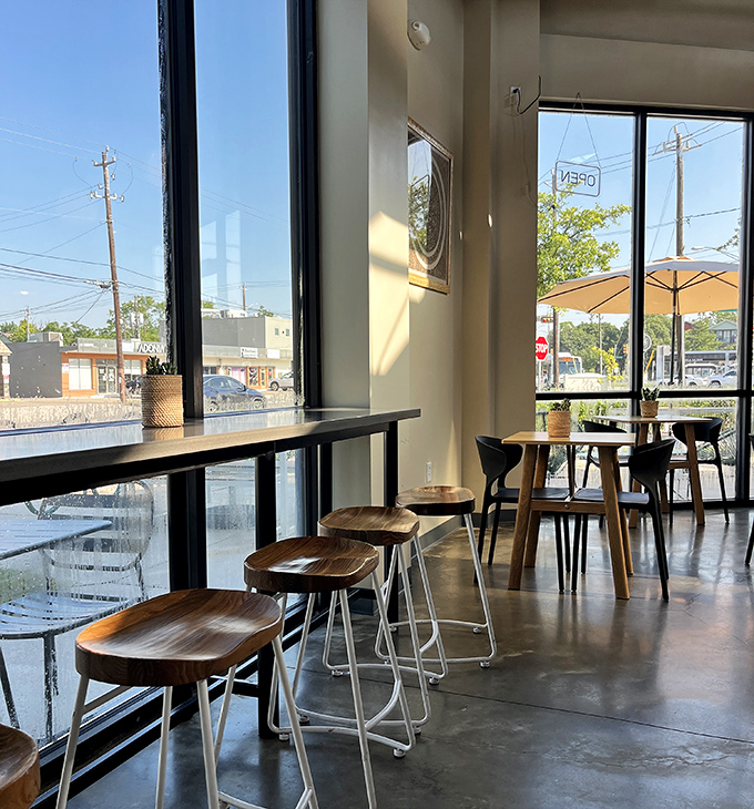 Sunlight floods the minimalist interior, where wooden stools and concrete floors create a space that says, "We're serious about food, not about pretension."