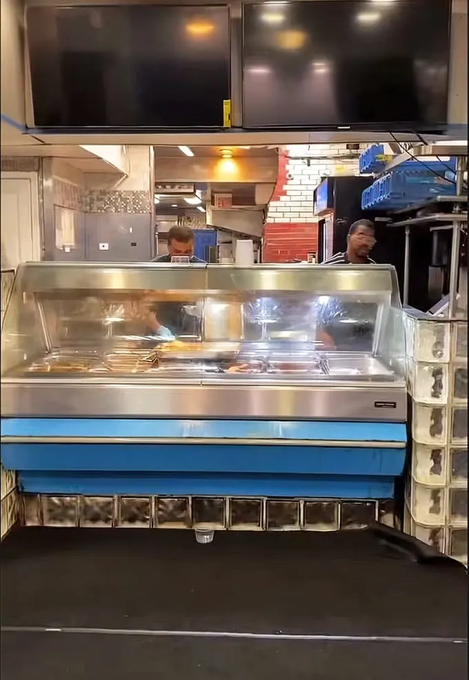 Behind the counter, culinary magic happens. This no-frills setup focuses on what matters most – getting exceptional food from their hands to yours.