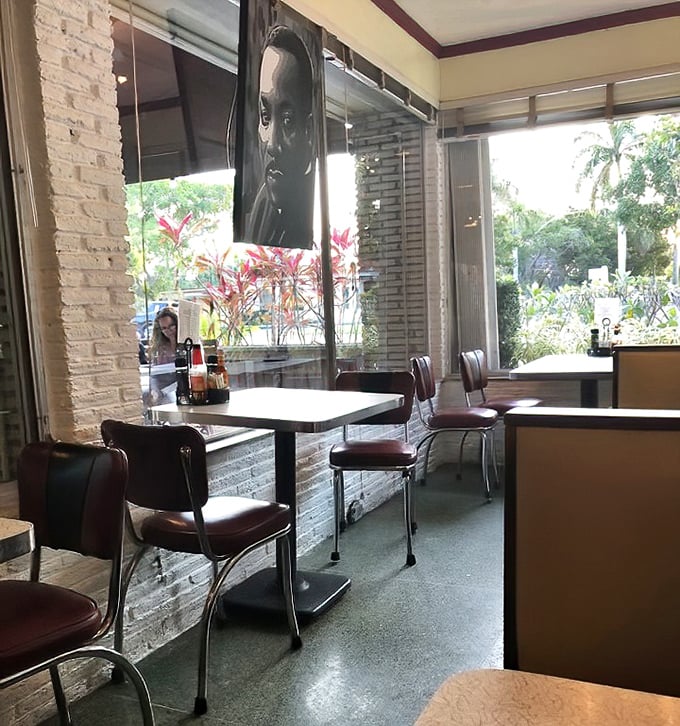 Classic red vinyl chairs against white brick walls create that perfect retro vibe—like sitting in a living postcard from 1950s Florida that somehow serves incredible food. 